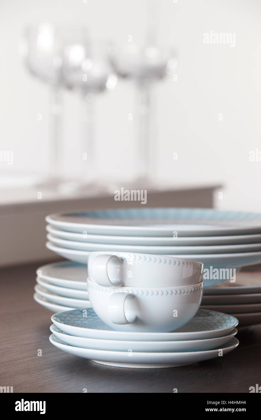 Crockery set over a table and cups with white background. Vertical ...