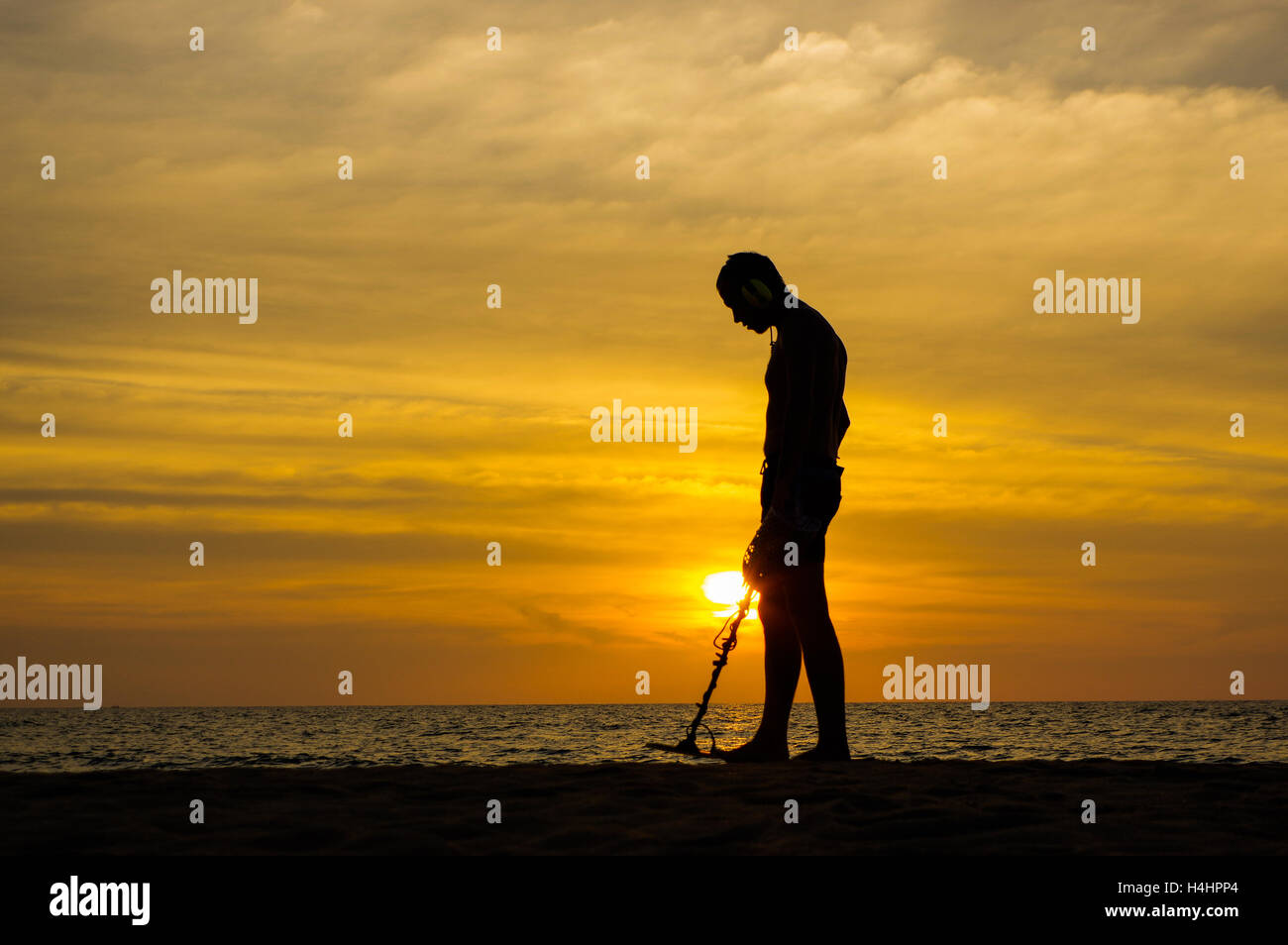 a treasure hunter with Metal detector on sunset on the beach Stock ...