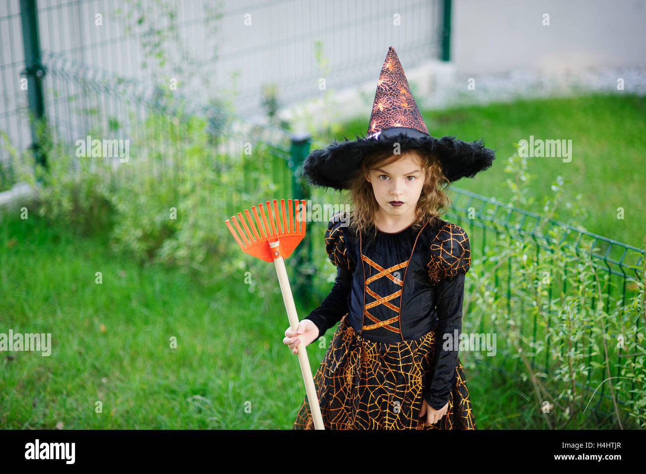 Preparation for Halloween. The girl in a suit of the evil witch cleans ...