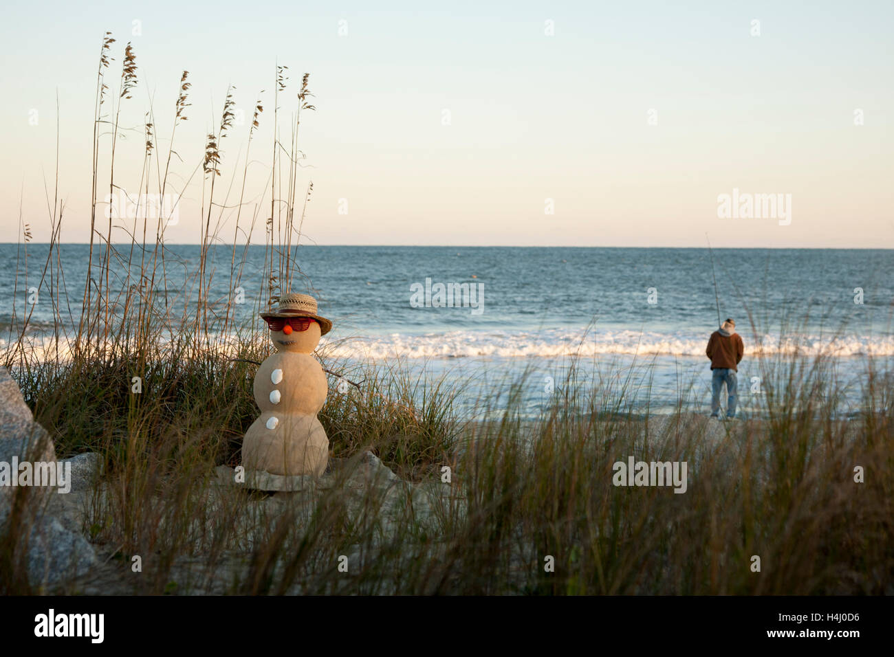 Snowman Made of Sand on the Beach with Grass and Fisherman Stock Photo ...