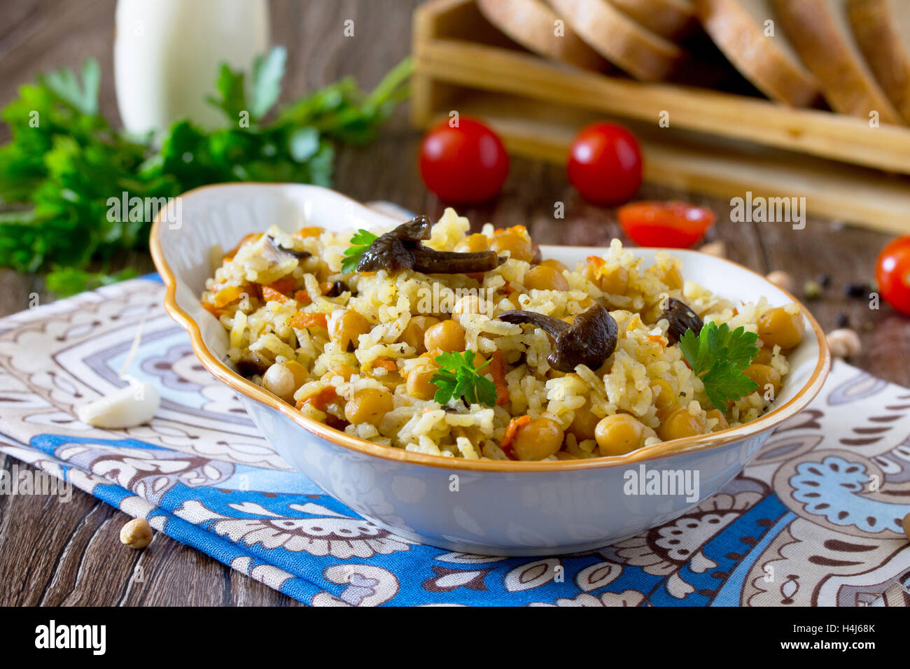 Vegetarian vegetable pilaf chickpea and wild mushrooms on a wooden ...