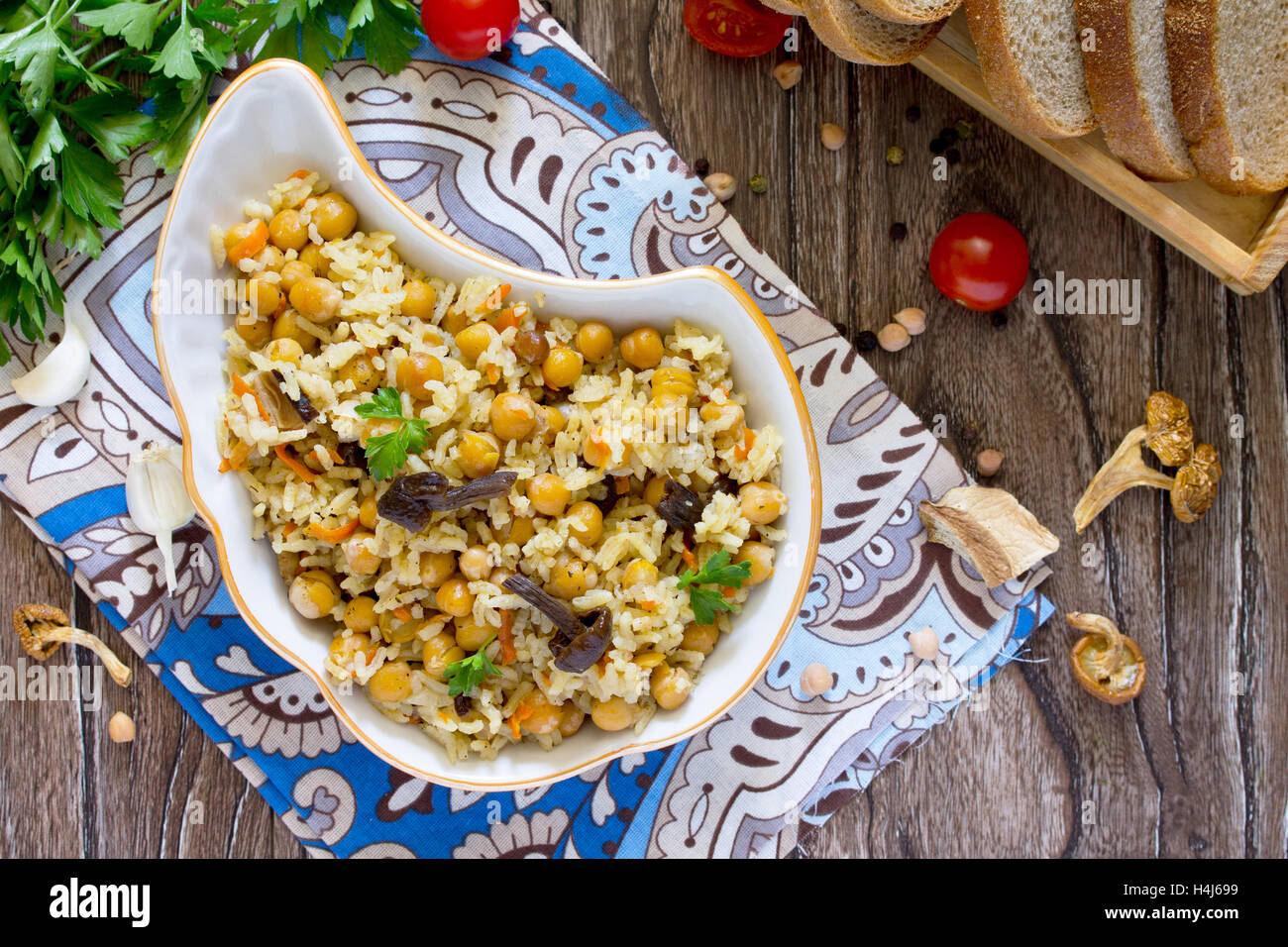 Vegetarian vegetable pilaf chickpea and wild mushrooms on a wooden ...