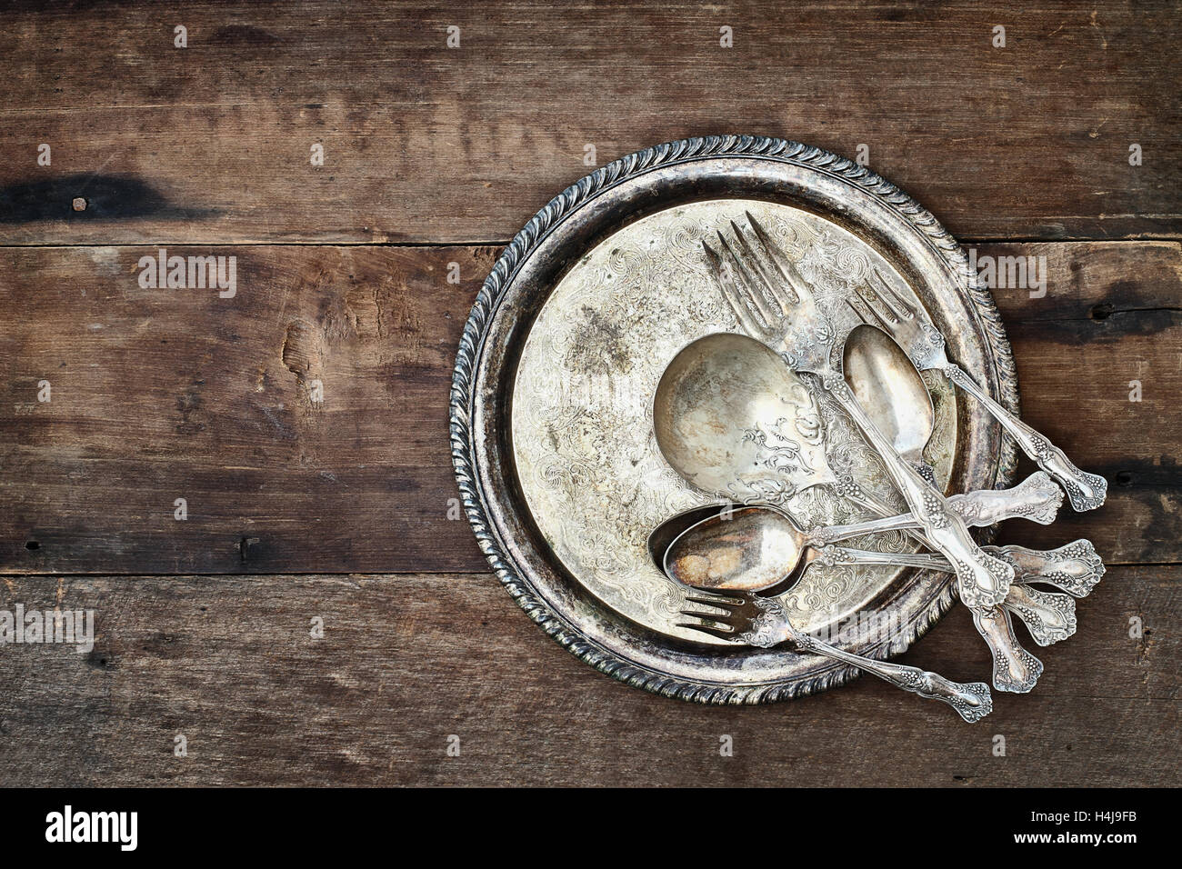 Antique silverware and plate over a rustic old wooden background. Image ...