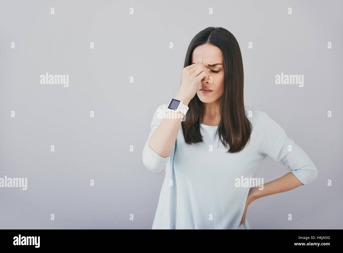Young sad woman standing against white background Stock Photo - Alamy