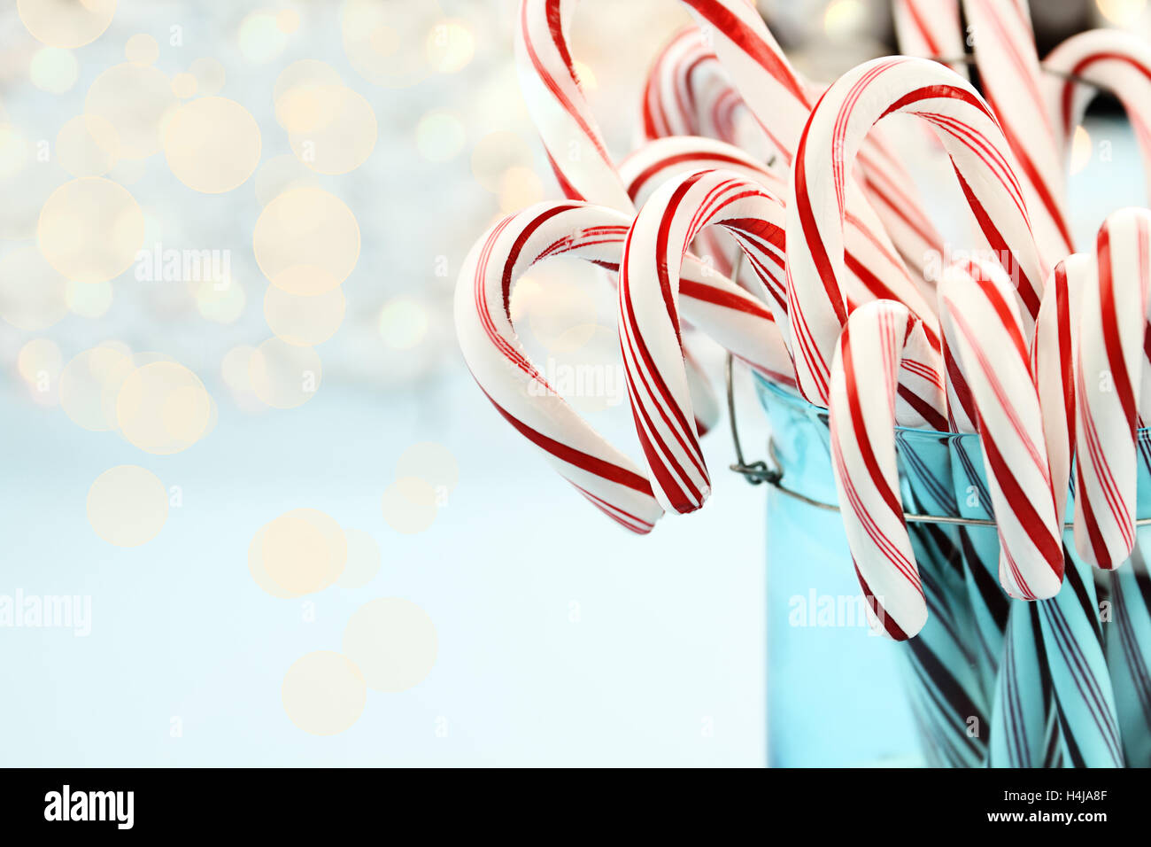Candy canes in a pretty glass blue Container. Extreme shallow depth of ...