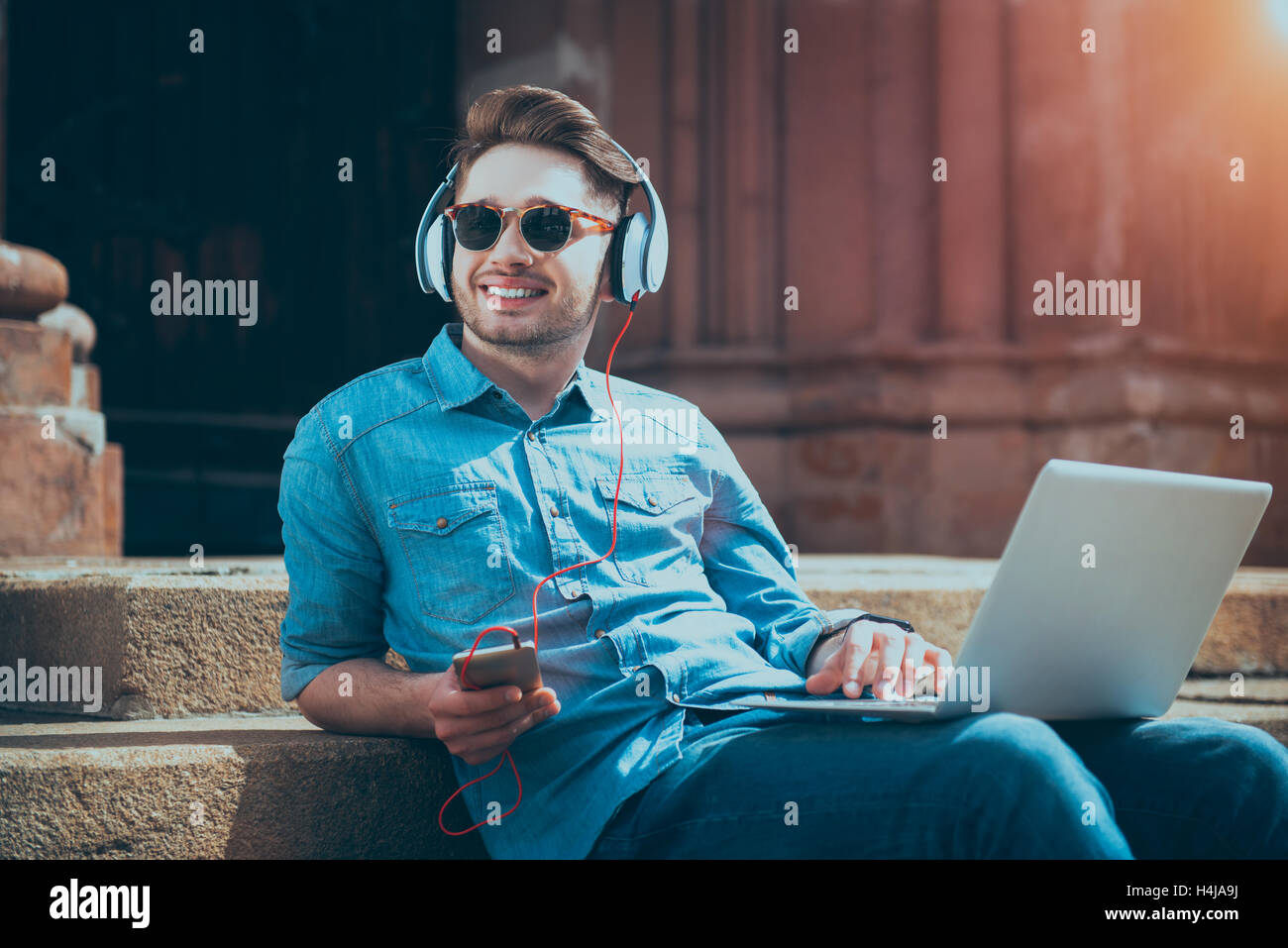 Positive handsome guy listening to music Stock Photo - Alamy
