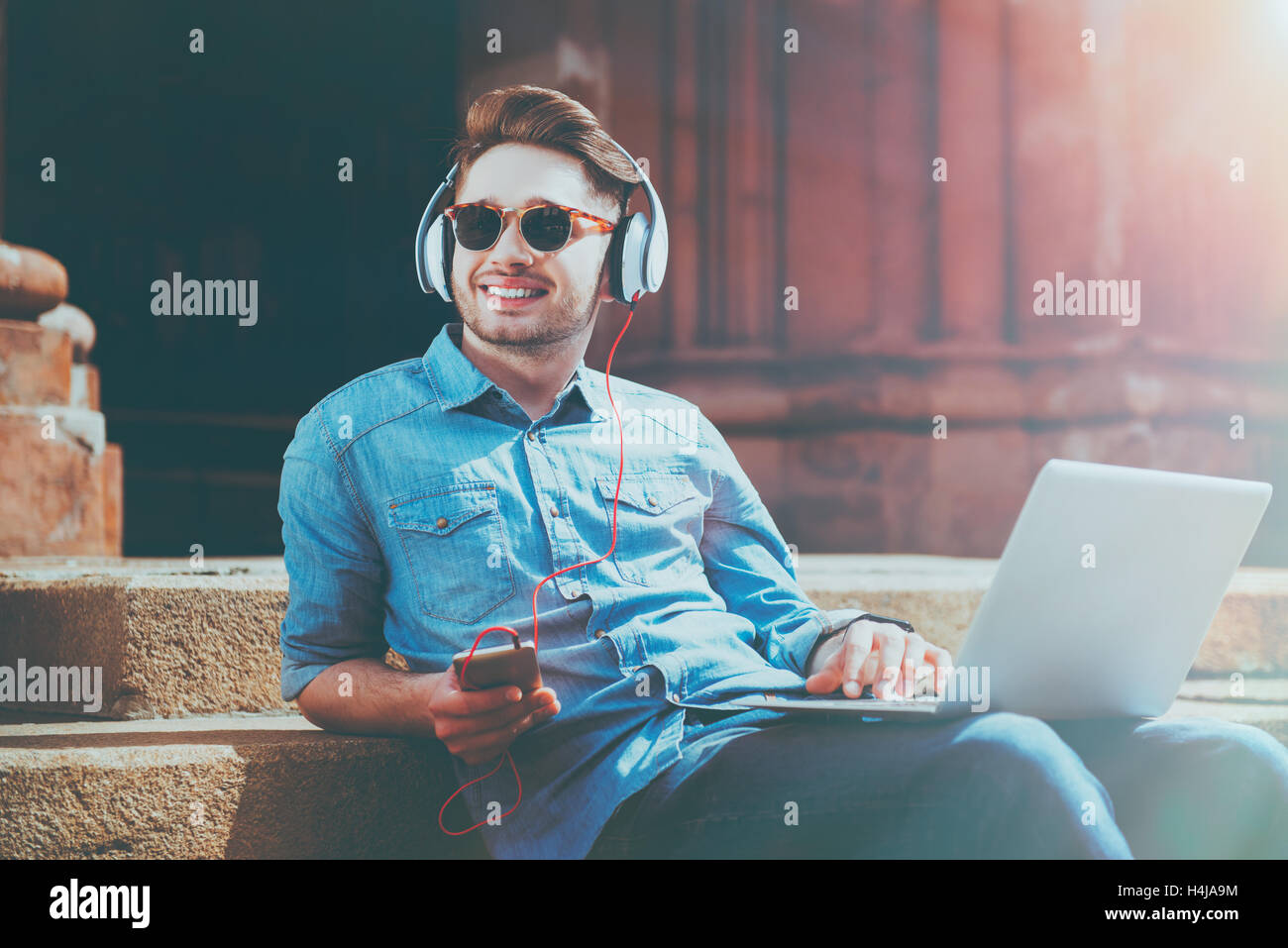 Cheerful handsome guy listening to music Stock Photo - Alamy