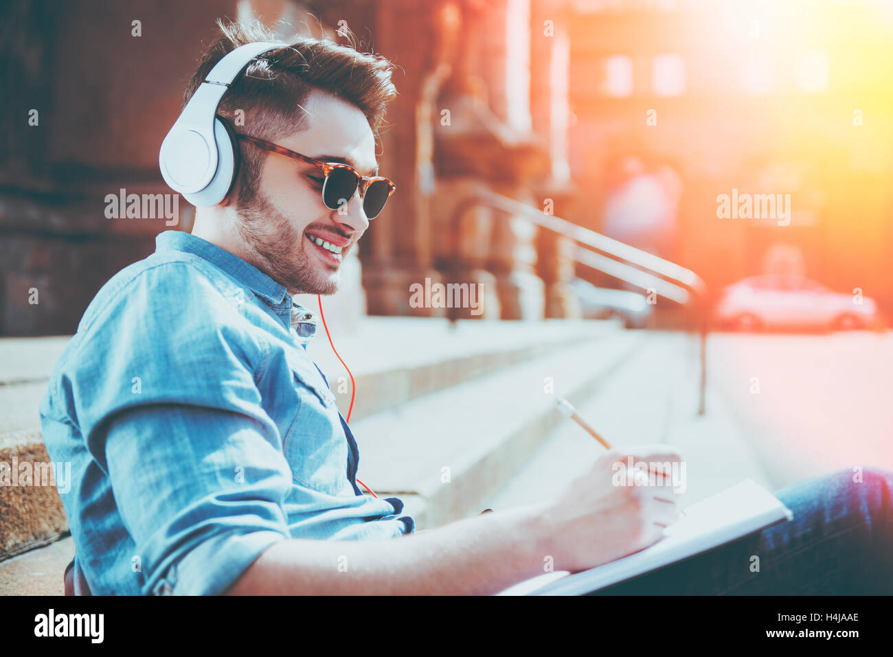 Smiling young sitting on the footsteps Stock Photo - Alamy