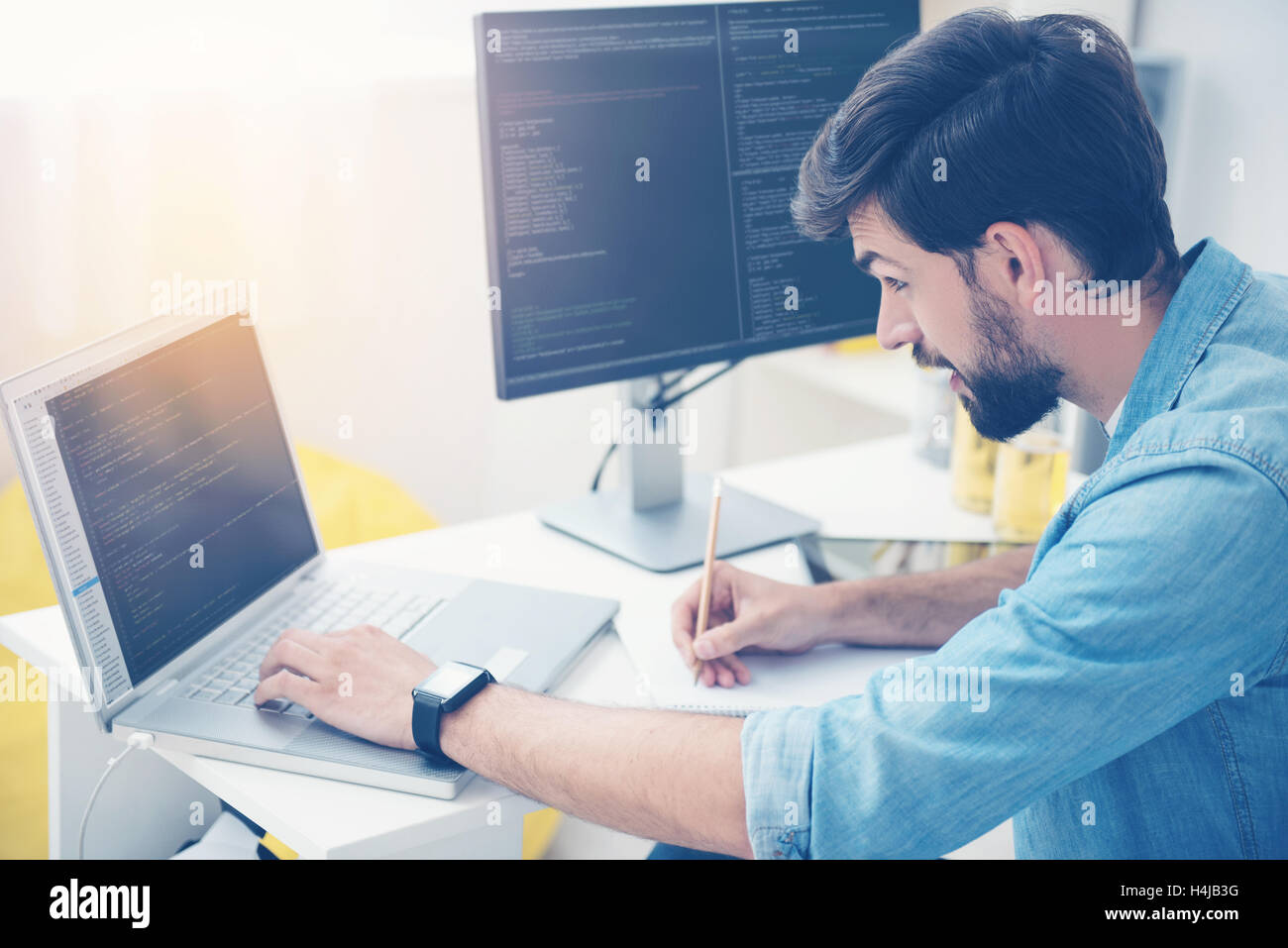 Concentrated man coding on a laptop Stock Photo - Alamy