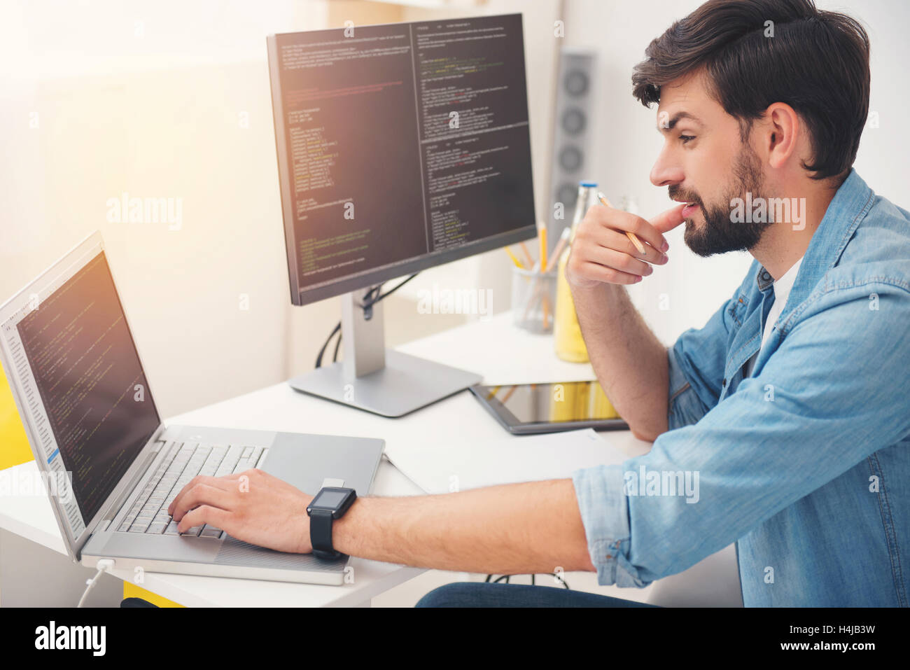 Delighted programmer working on a laptop Stock Photo - Alamy