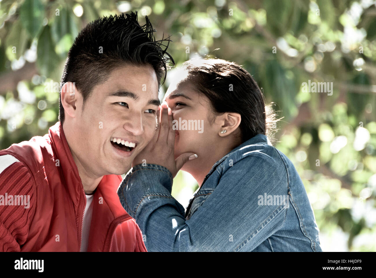 Girl with a secret Teenage girl whispers a secret into the ear of a ...