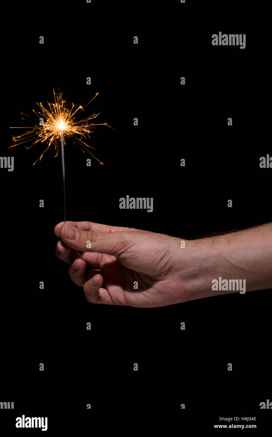 Hand holding sparkler on black background Stock Photo - Alamy