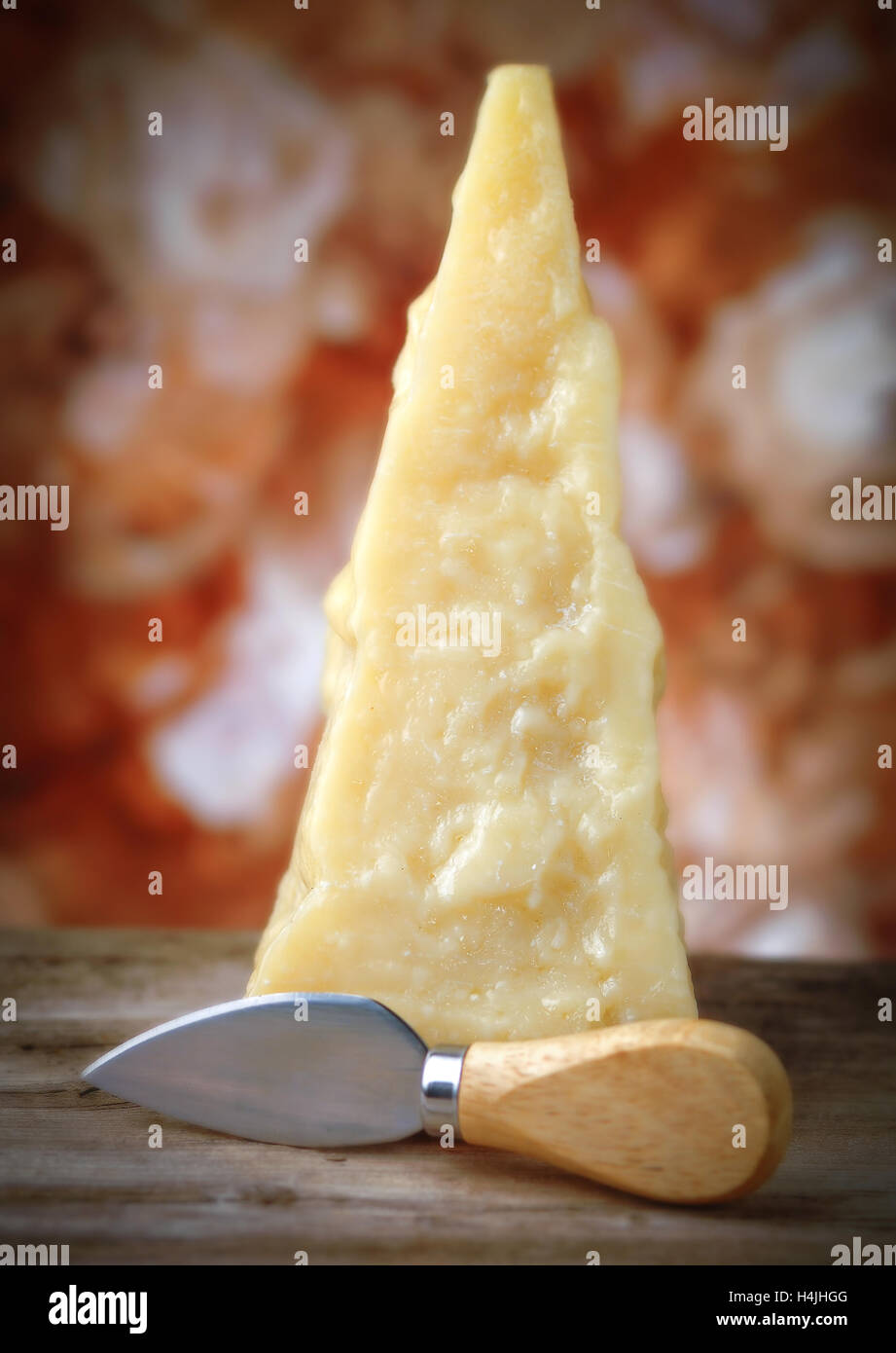 Slice of Italian parmesan cheese on wooden table Stock Photo - Alamy