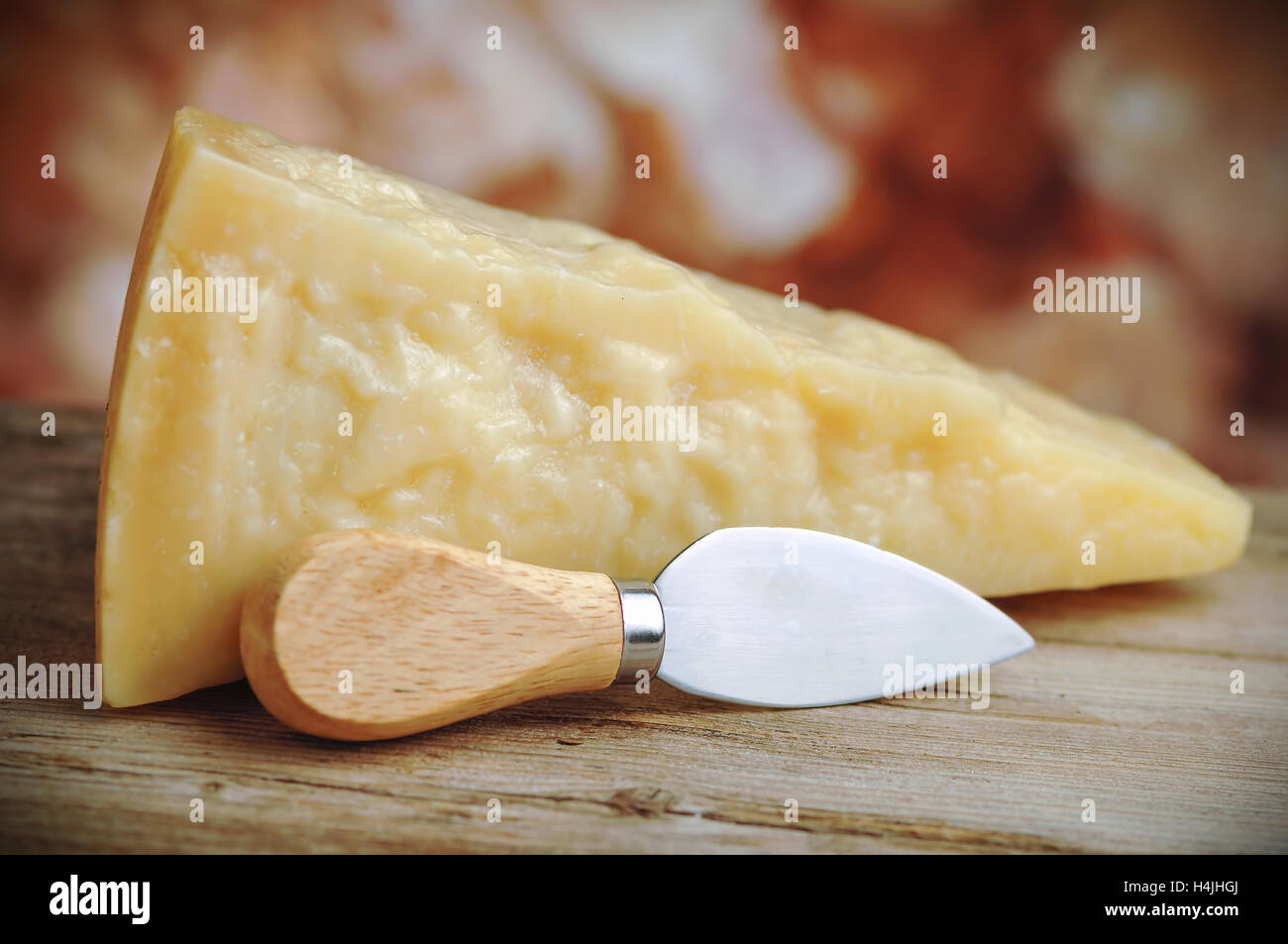 Slice of Italian parmesan cheese on wooden table Stock Photo - Alamy