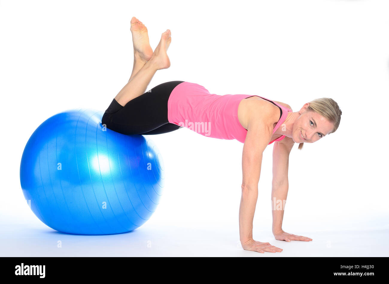 Athletic woman doing pilates exercises balancing with her knees on the ...