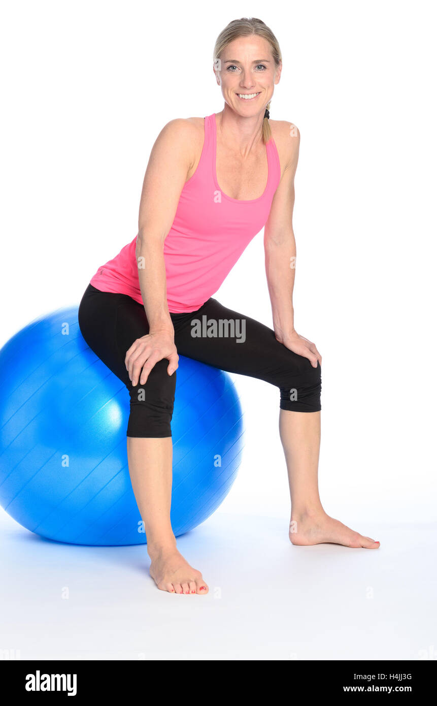 Friendly attractive fit young woman sitting barefoot in sportswear on a ...
