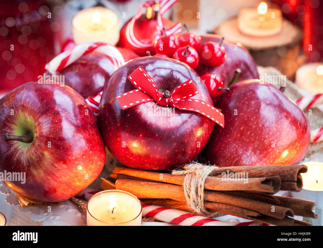 Christmas composition with red apples, cinnamon, toy and candles Stock ...
