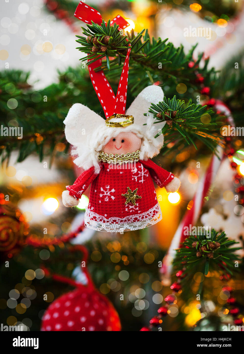 Decorative Christmas angel on a festive xmas tree and garland ...