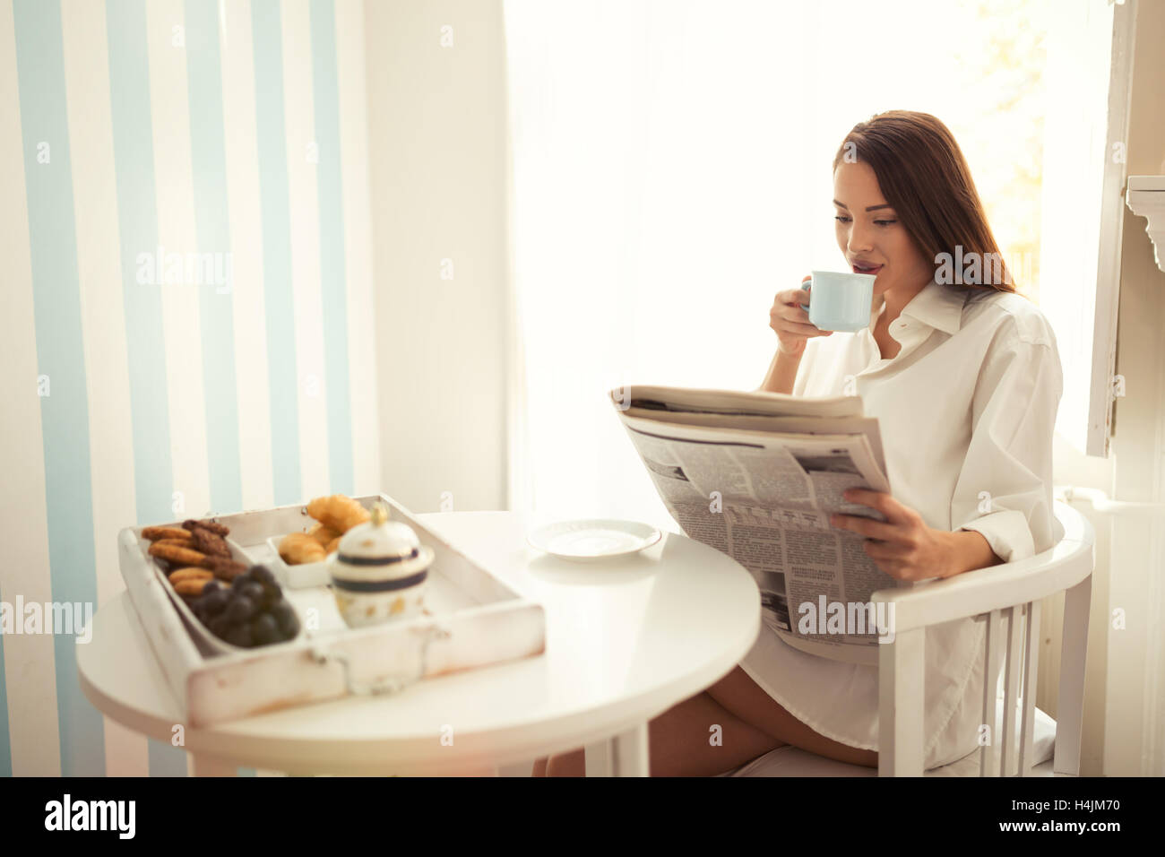 Beautiful woman reading morning paper and drinking coffee Stock Photo ...
