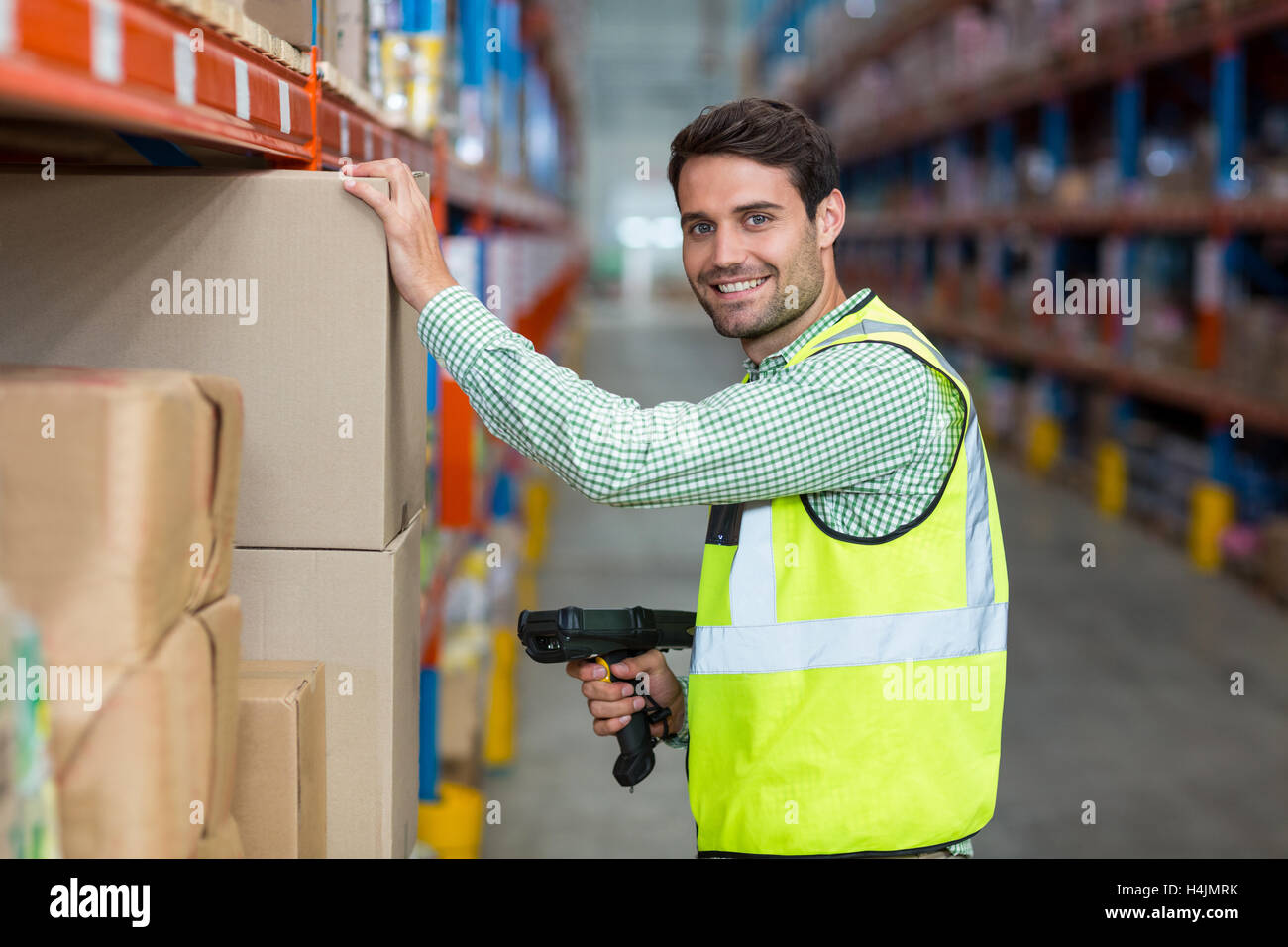Portrait of smiling warehouse worker scanning box Stock Photo - Alamy