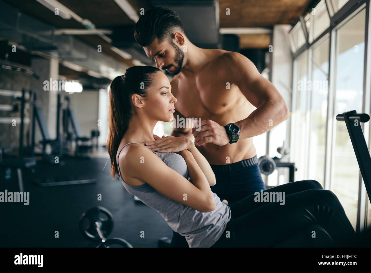 Personal trainer giving instructions to student in gym Stock Photo - Alamy