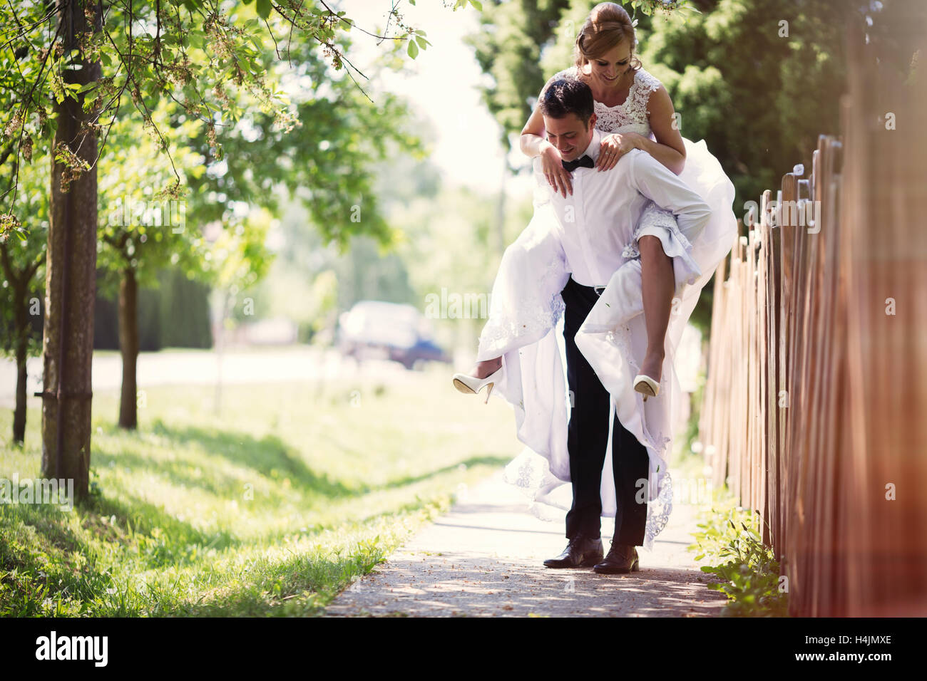 Groom carrying bride piggyback outdoors Stock Photo - Alamy