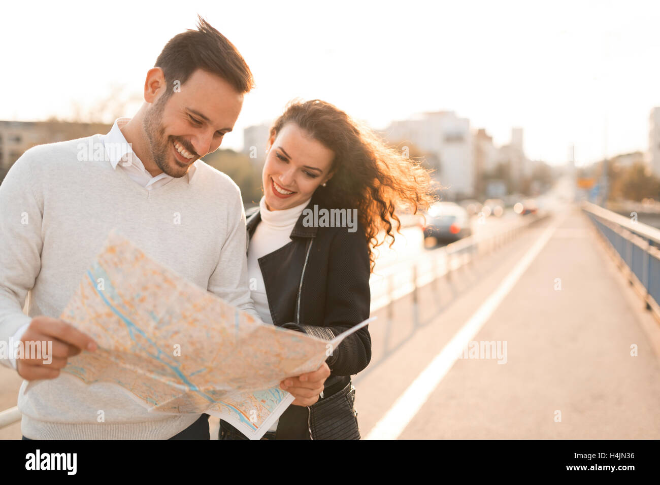 Couple in love exploring city by map Stock Photo - Alamy
