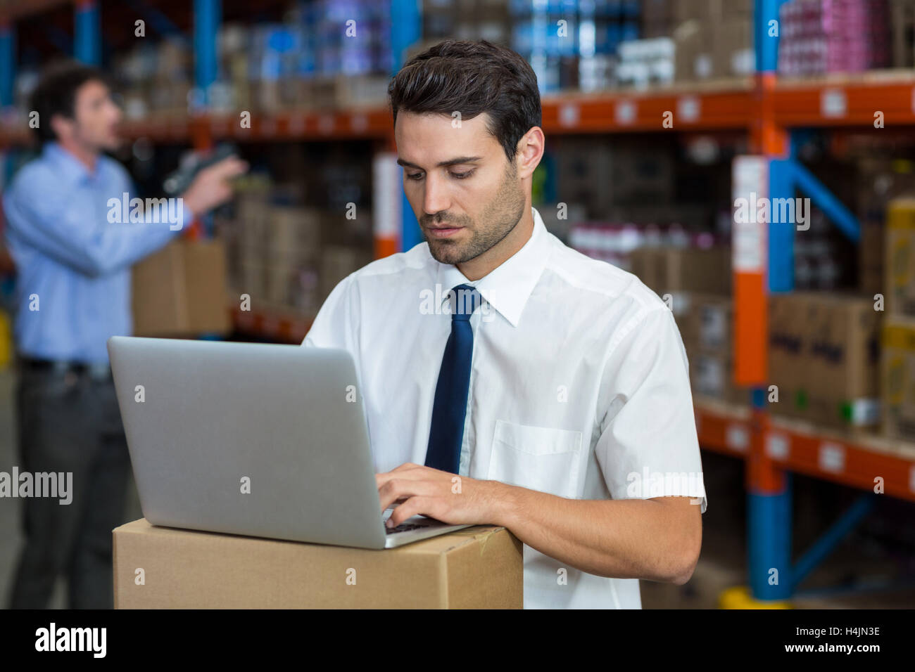 Warehouse manager working on laptop Stock Photo - Alamy