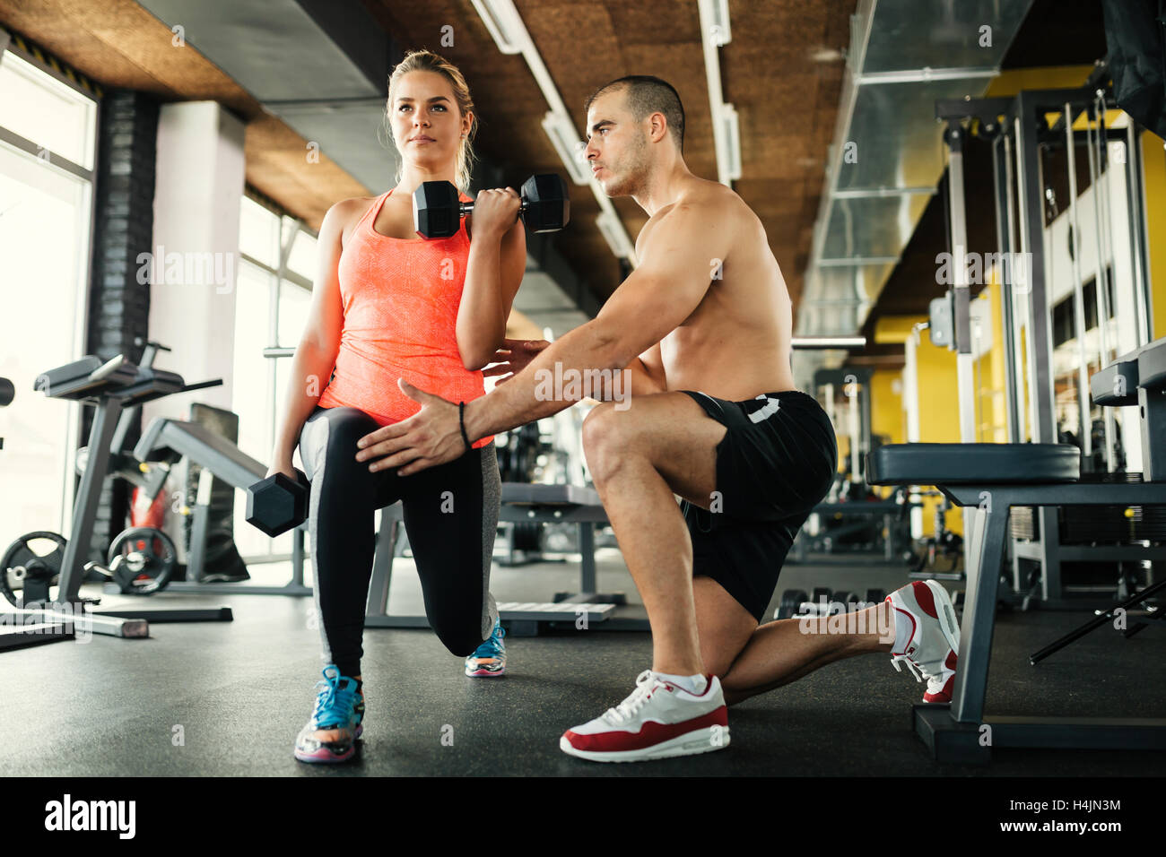 Personal trainer giving instructions to student in gym Stock Photo - Alamy