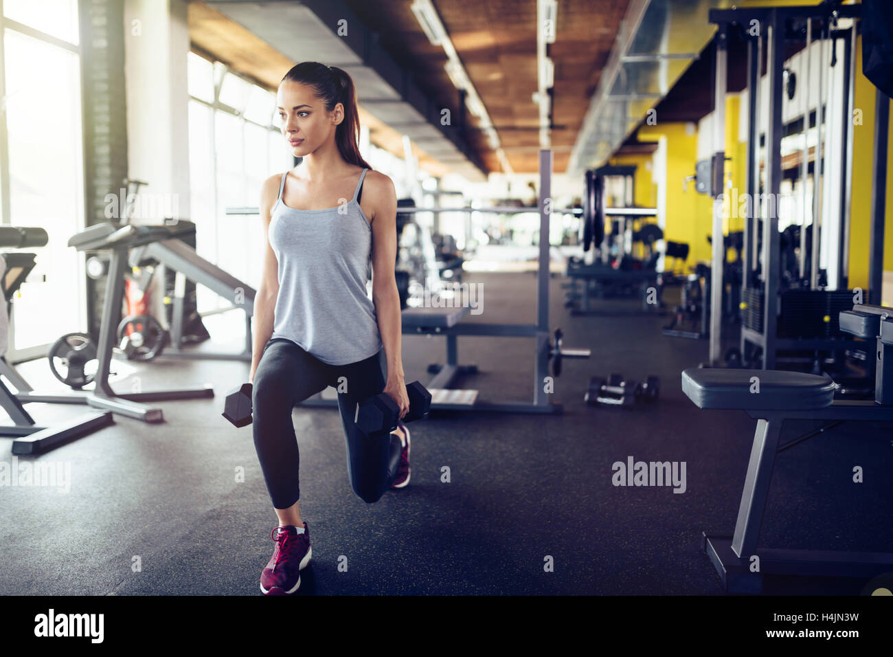 Beautiful woman working out in gym and lifting weights Stock Photo - Alamy