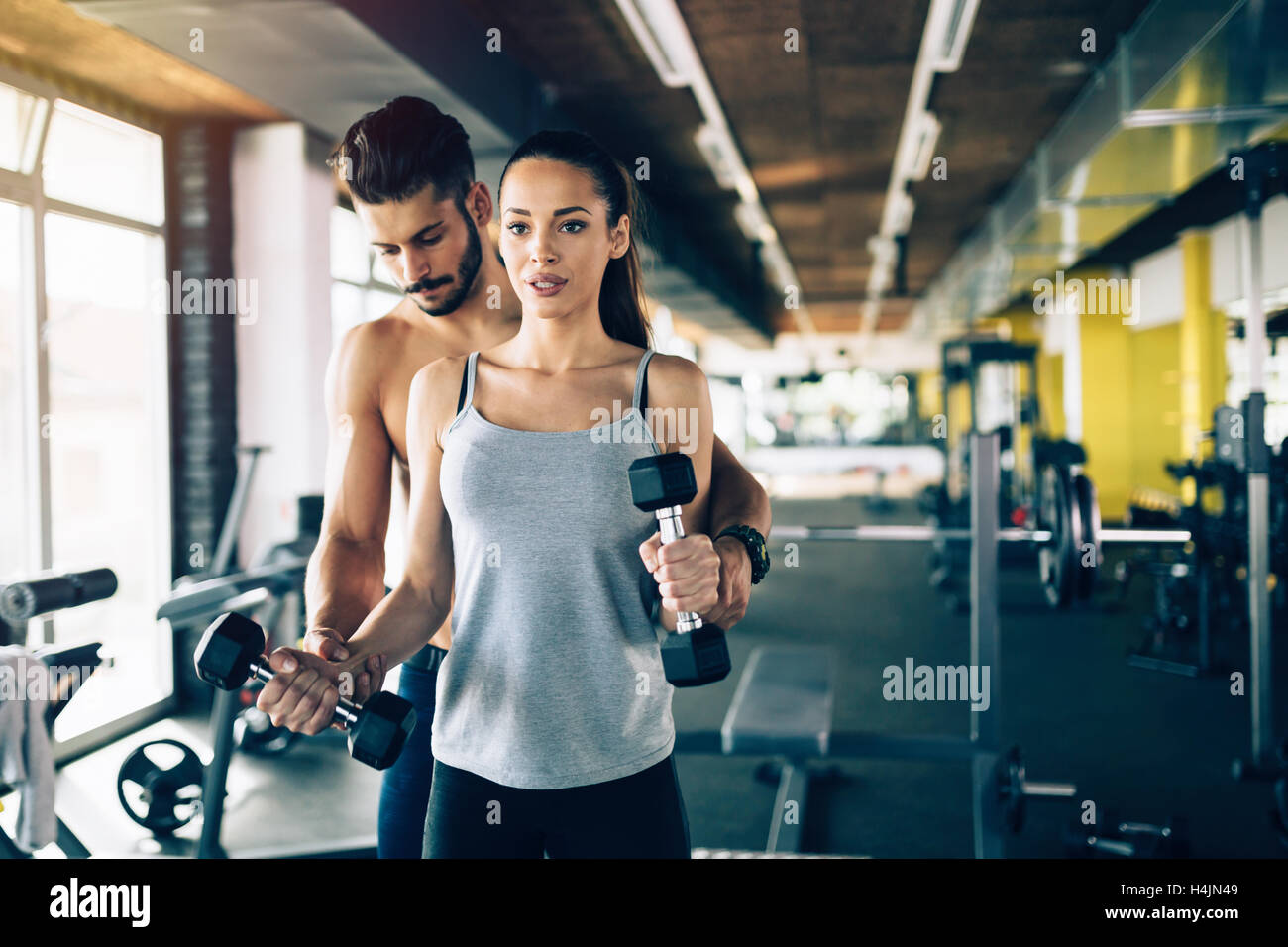 Personal trainer giving instructions to student in gym Stock Photo - Alamy