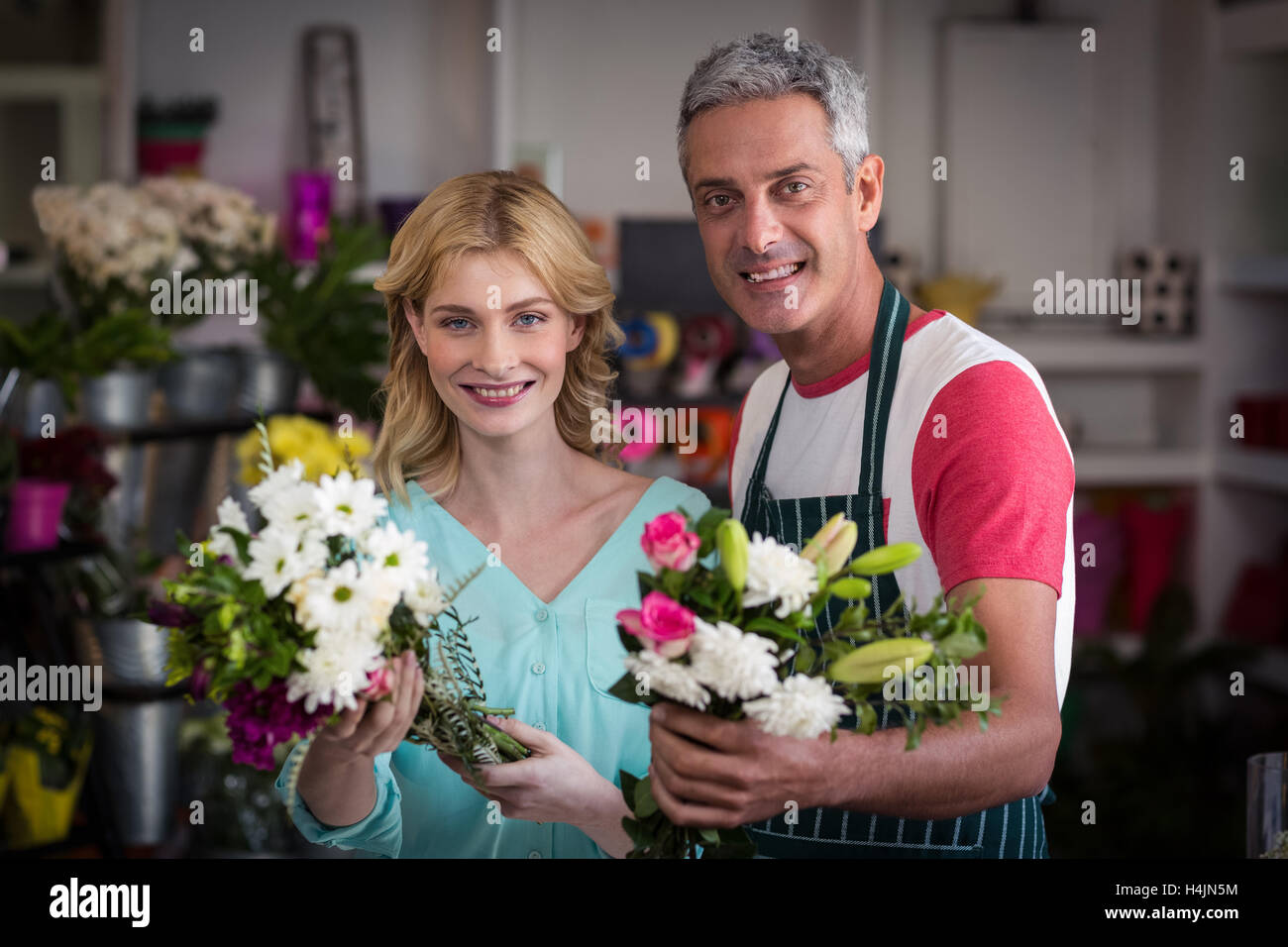 Smiling florists holding bunch of flowers in flower shop Stock Photo ...