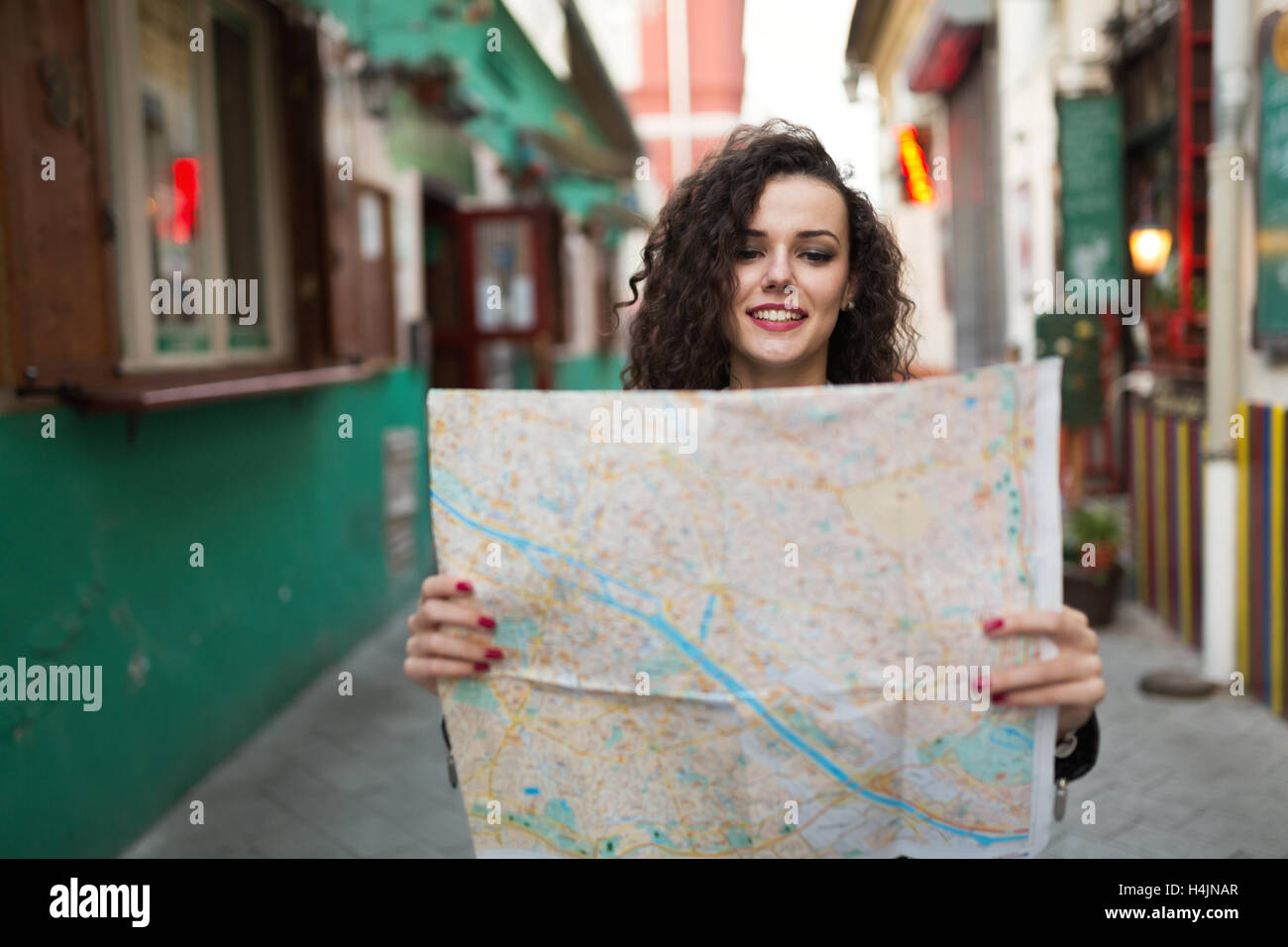 Female tourist exploring city while holding map Stock Photo - Alamy