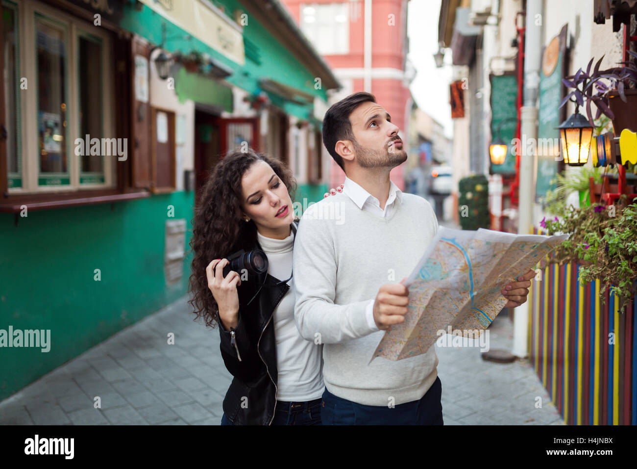 Tourist couple searching for destination by looking at map Stock Photo ...