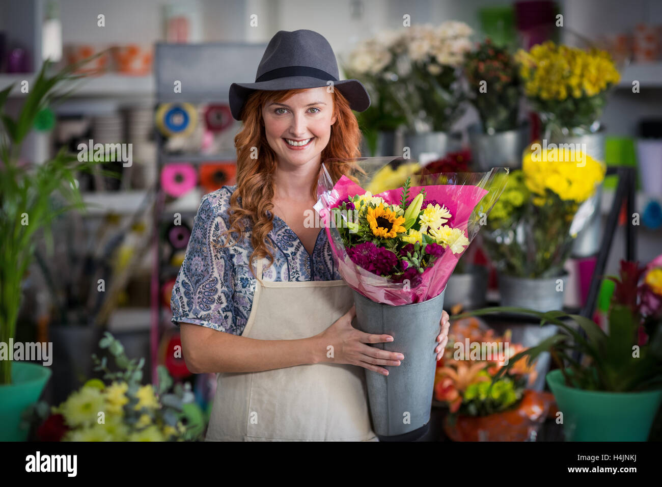 Happy female florist holding flower vase Stock Photo - Alamy