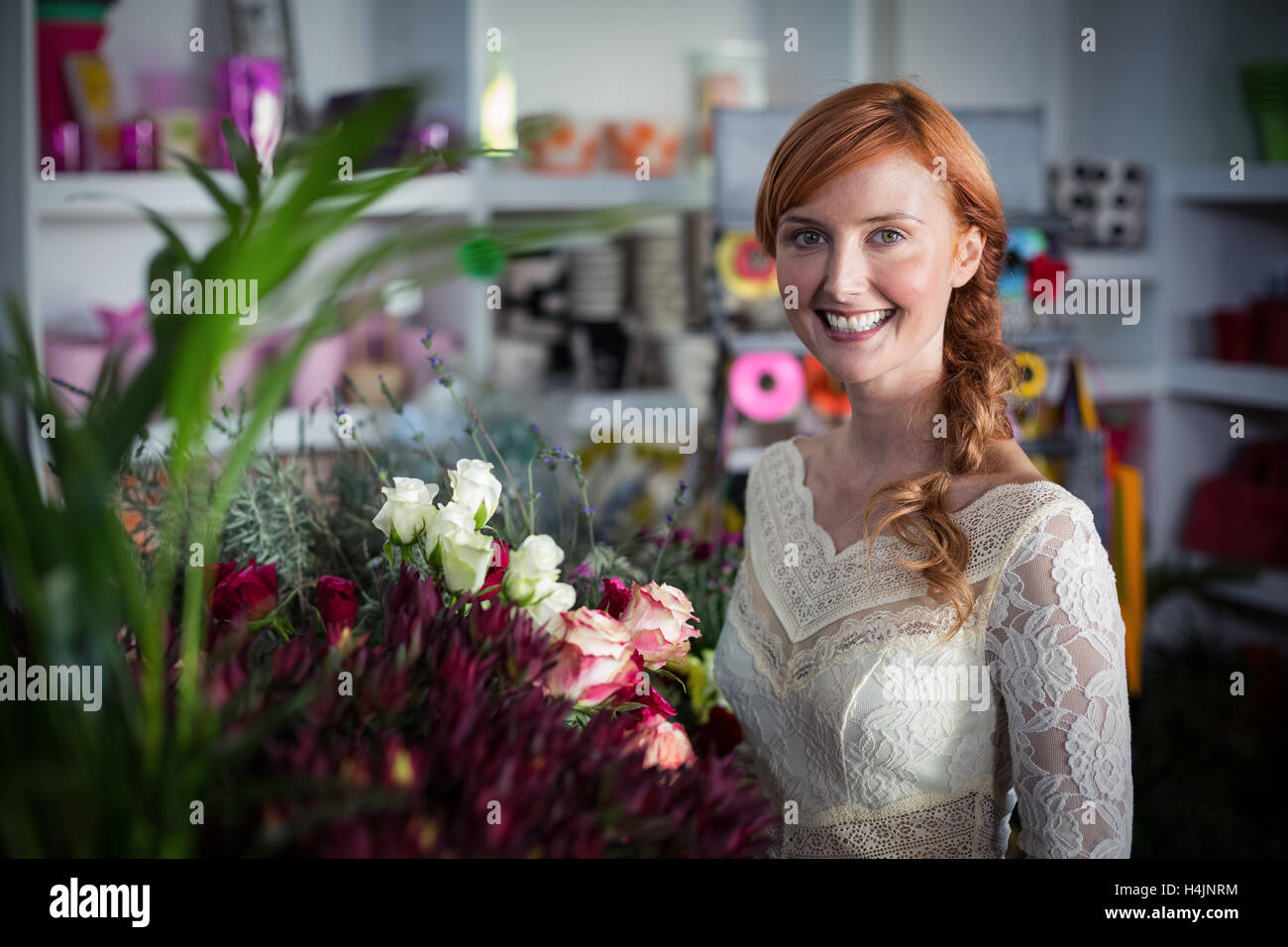 Female florist standing and smiling Stock Photo - Alamy
