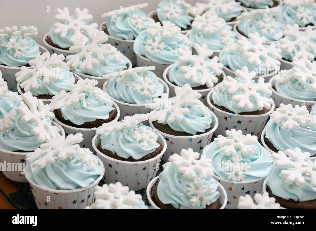 cup cakes with snowflakes decorating in the color of light blue for a ...