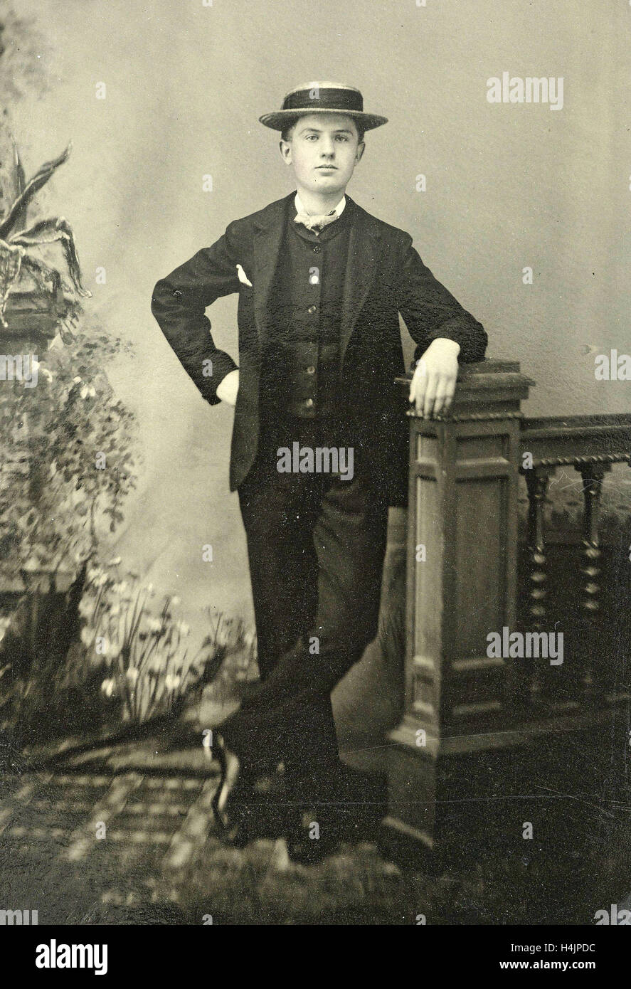 Portrait of a young man standing at a railing for a painted backdrop ...