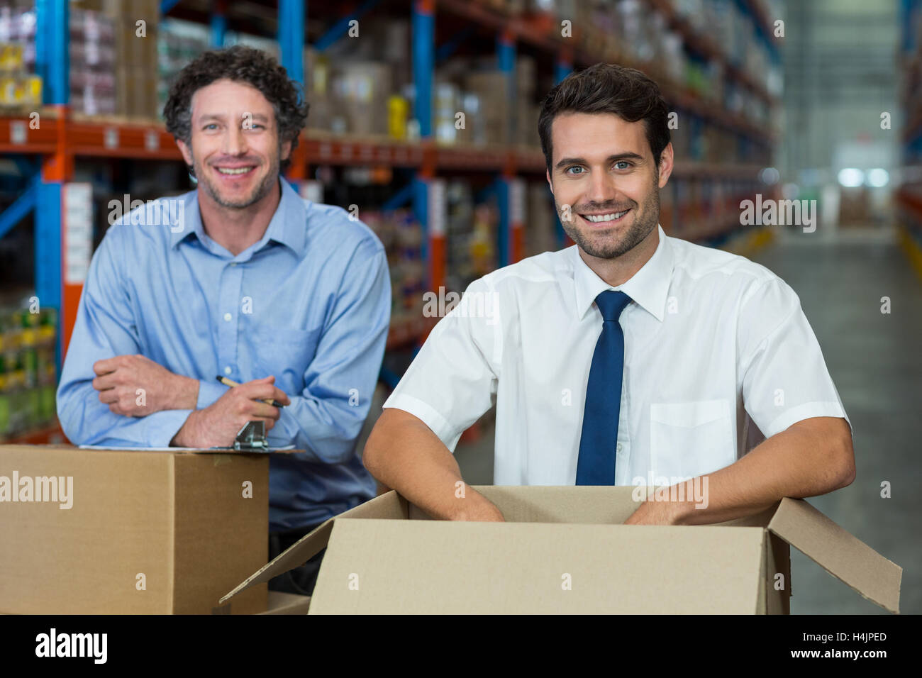 Portrait of two warehouse workers standing together with boxes Stock ...