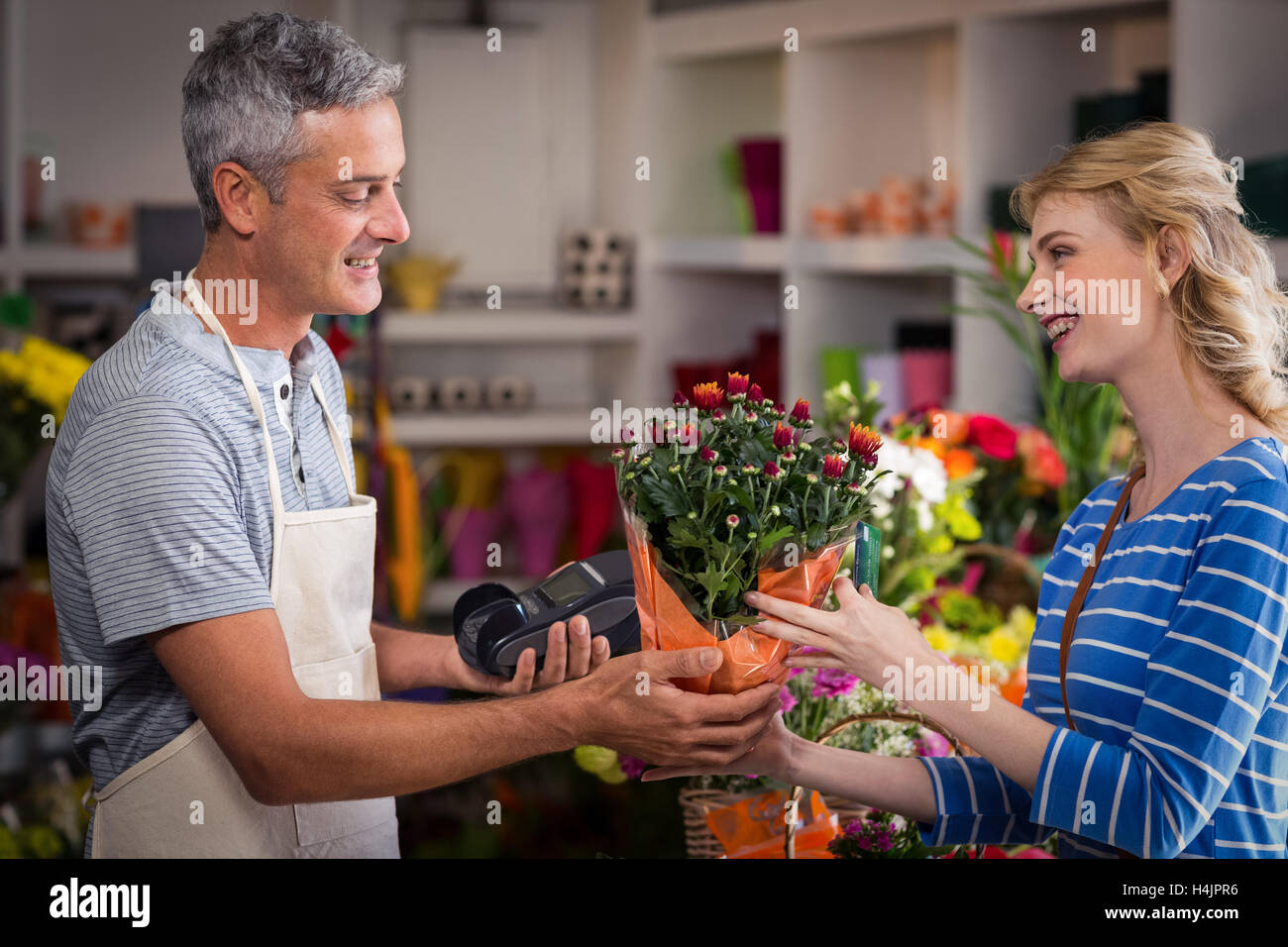 Florist giving bouquet of flower to woman Stock Photo - Alamy