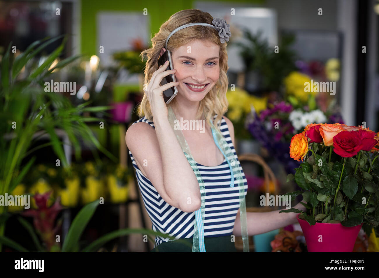 Female florist talking on mobile phone Stock Photo - Alamy
