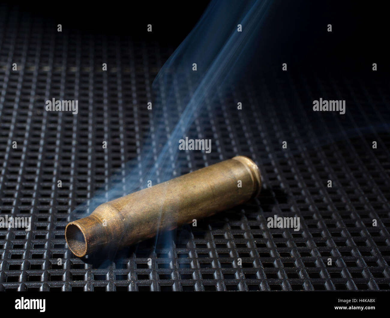 Empty rifle brass on a grate with smoke around Stock Photo - Alamy