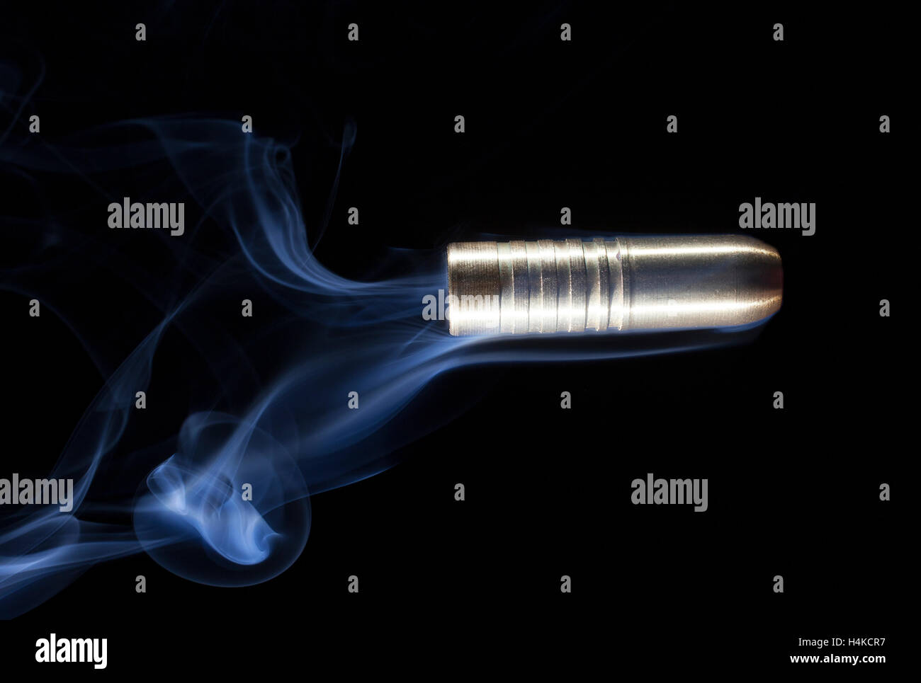 Large bullet with blue smoke behind on a black background Stock Photo ...