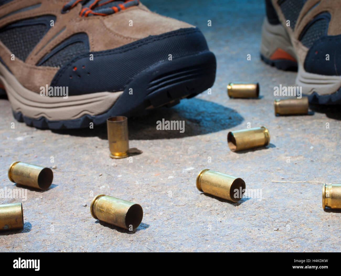 Tennis shoes surrounded by empty handgun ammuntion on concrete Stock ...