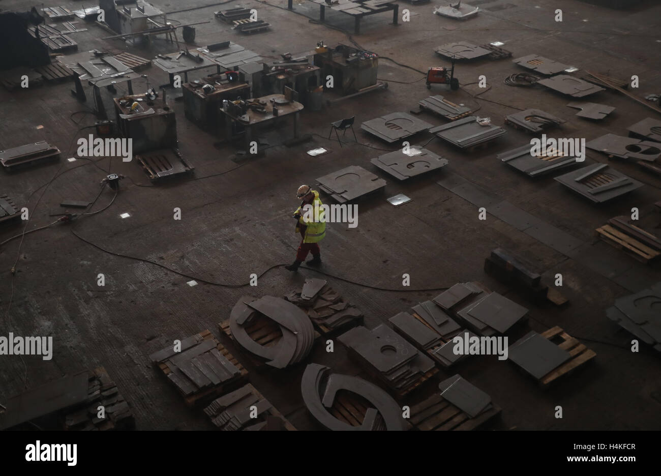 A worker walks amongst parts in the Construction Hall at Cammell Laird ...