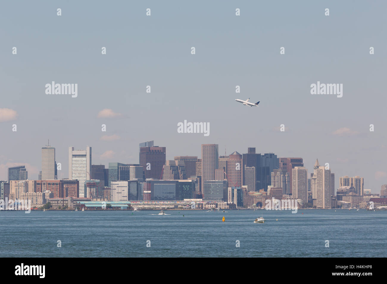 A photograph of a plane flying over the Boston Skyline, as seen from a ...