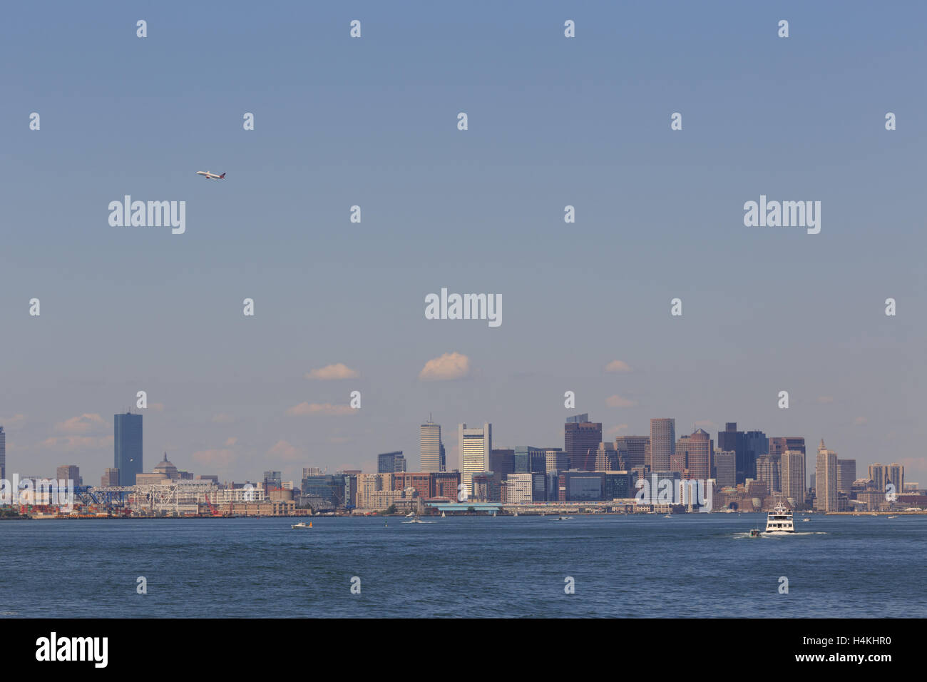 A photograph of a plane flying over the Boston Skyline, as seen from a ...
