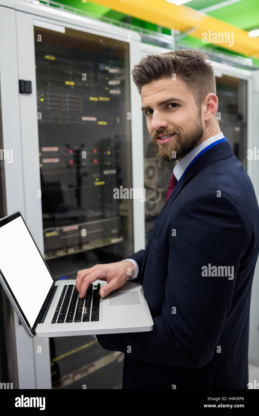 Technician using laptop while analyzing server Stock Photo - Alamy