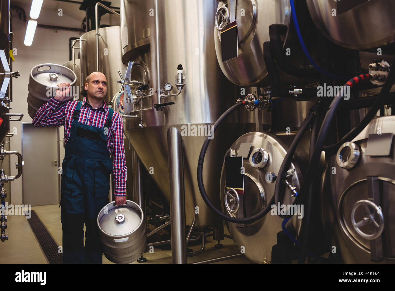 Worker carrying kegs Stock Photo - Alamy