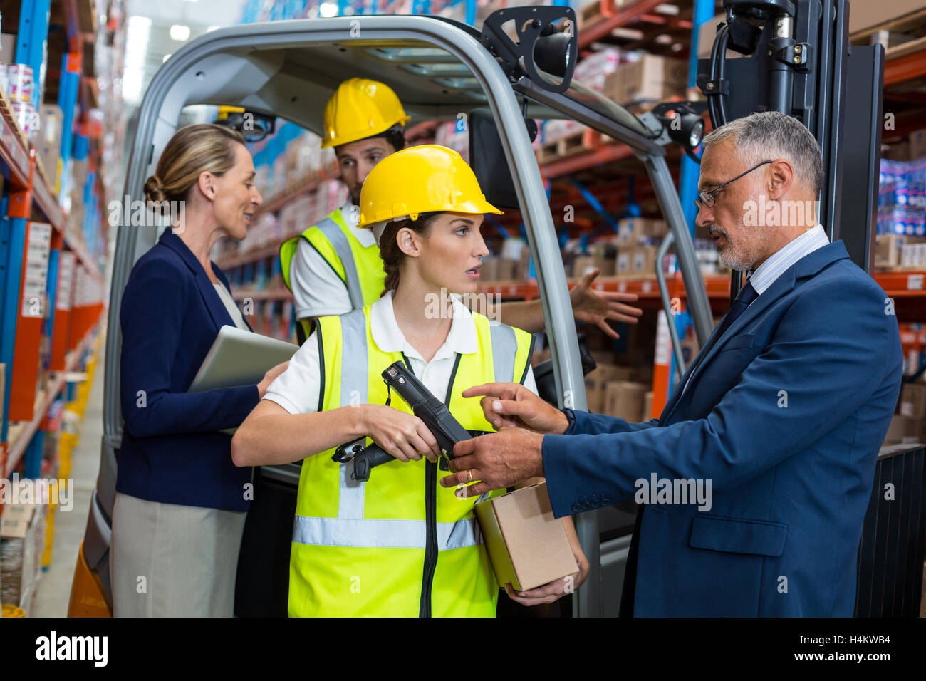 Warehouse manager and client interacting with co-workers Stock Photo ...